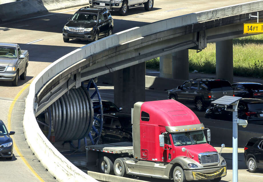 Large truck carrying spool stuck under bridge on Southwest Freeway at ...