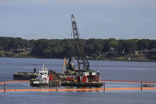 Tons of sawmill debris being removed from Muskegon Lake