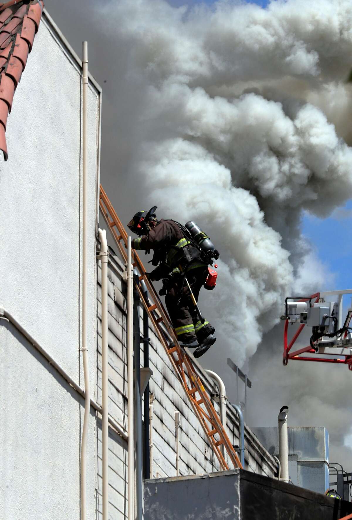 Firefighters rescue 2 people from roof of structure fire in Oakland