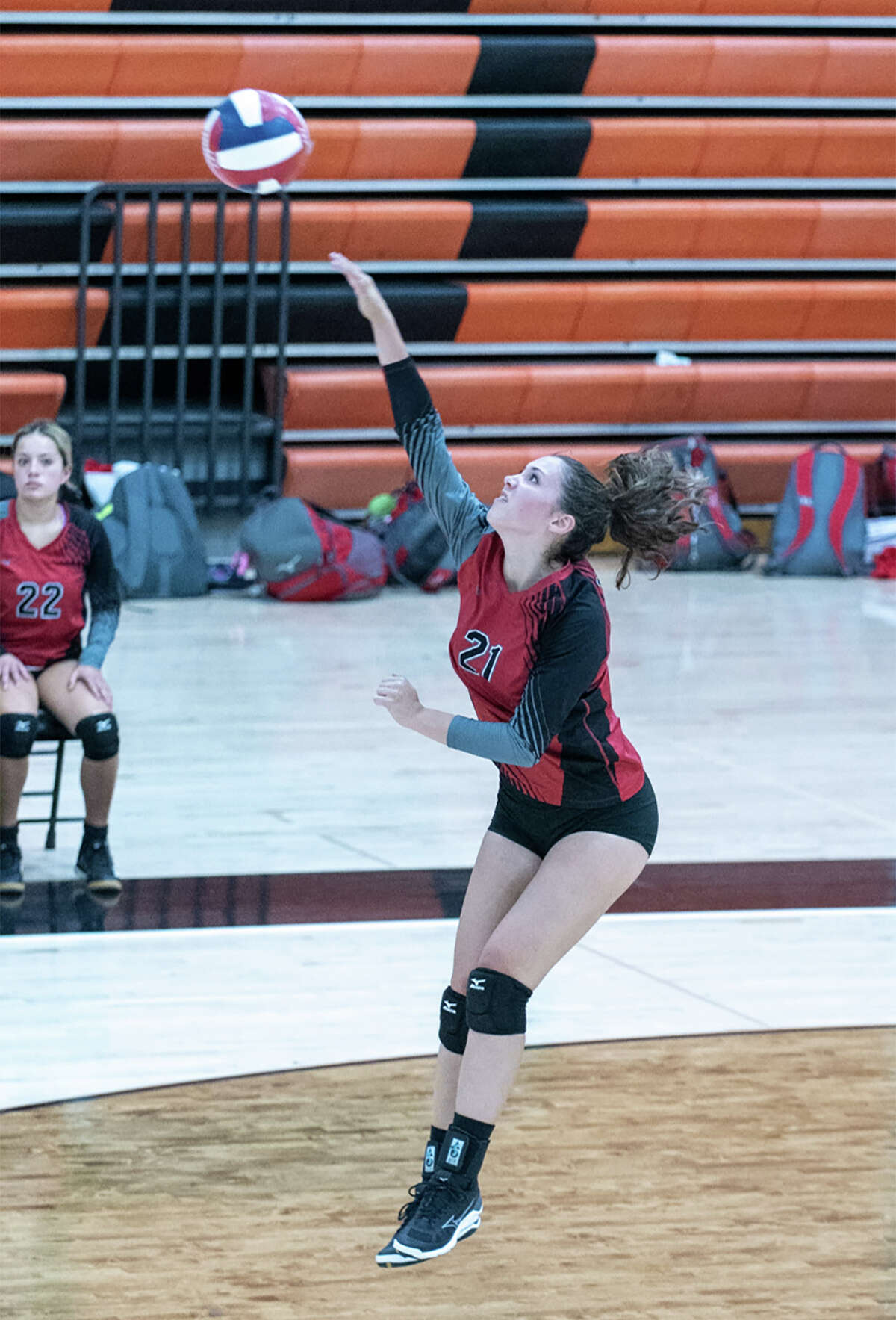 Cheshire volleyball's Avery Mola lands with Regis College.