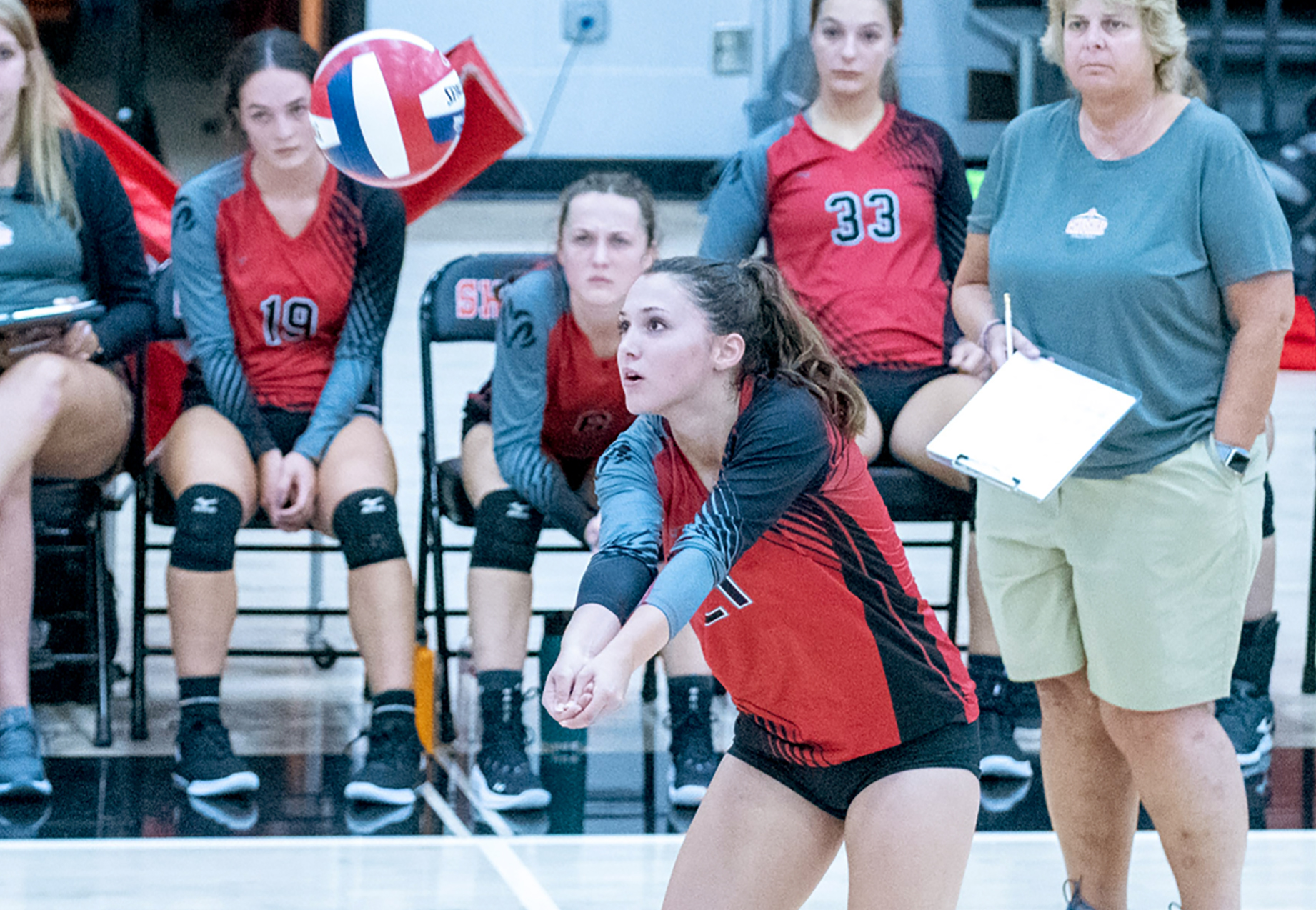 Cheshire volleyball's Avery Mola lands with Regis College.