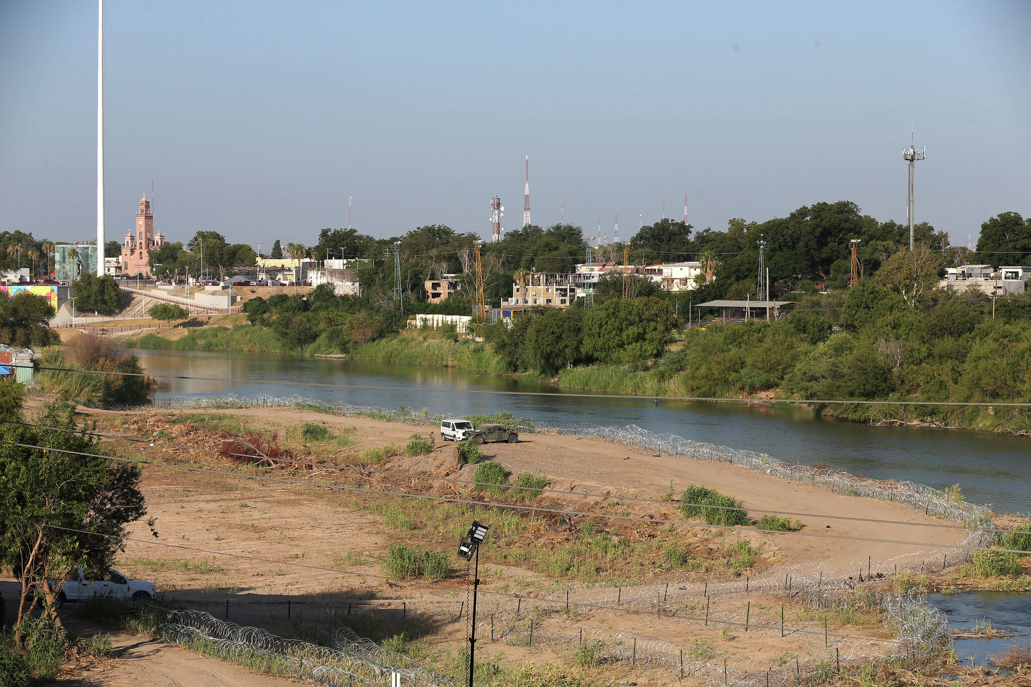 Man with AR-style rifle seen leading migrants across Rio Grande