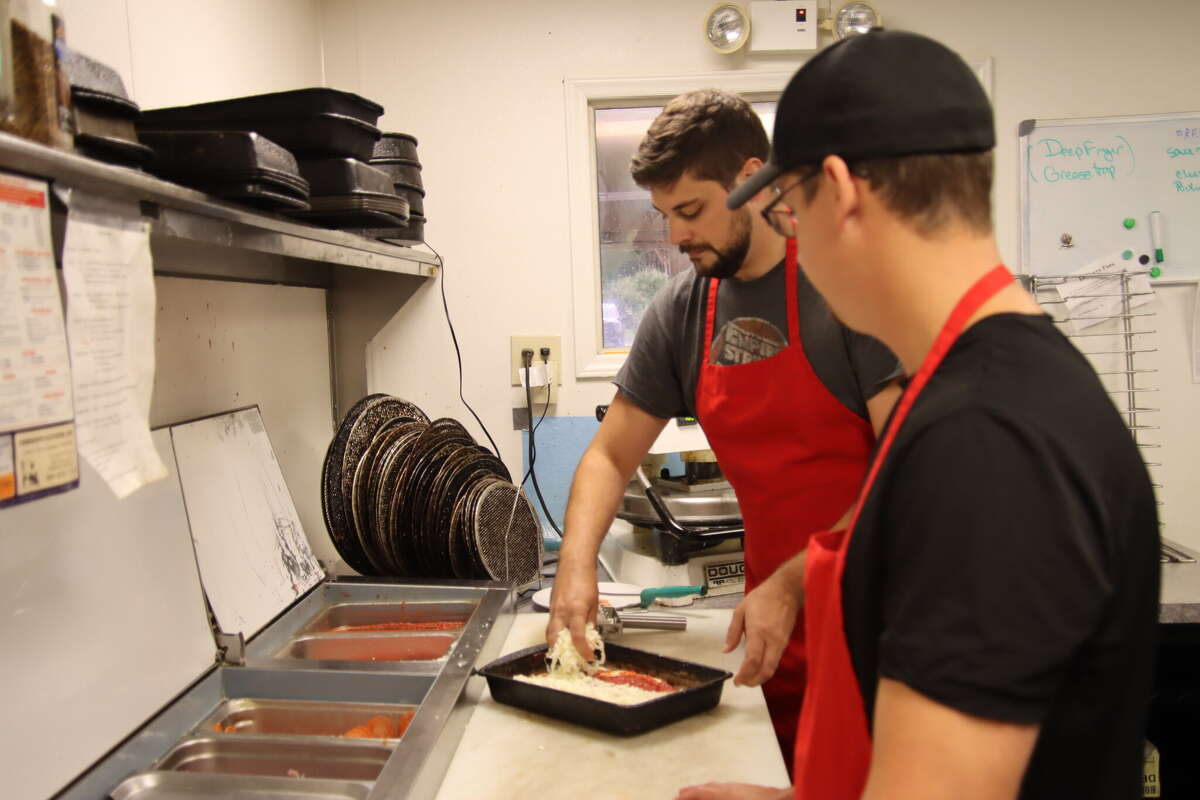 On the job: Max Milne puts together his first pizza with Pizza Dude