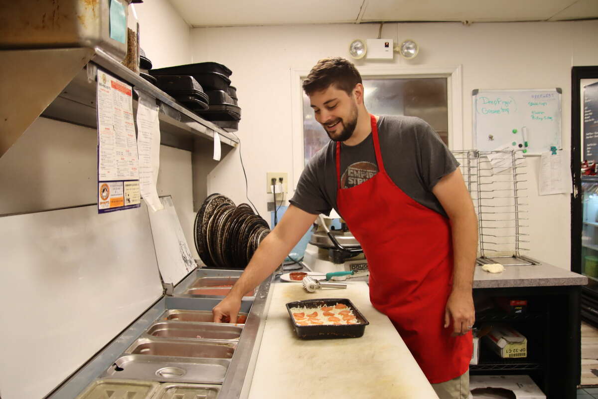 On the job: Max Milne puts together his first pizza with Pizza Dude