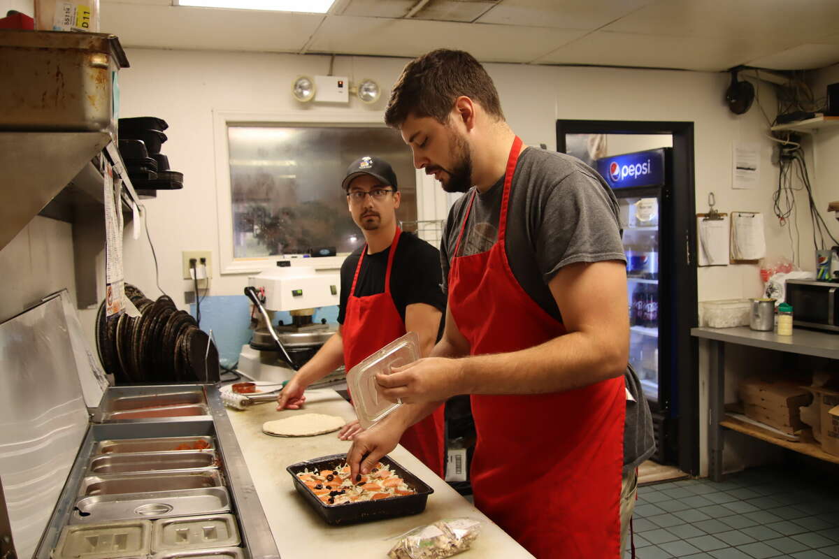On the job: Max Milne puts together his first pizza with Pizza Dude