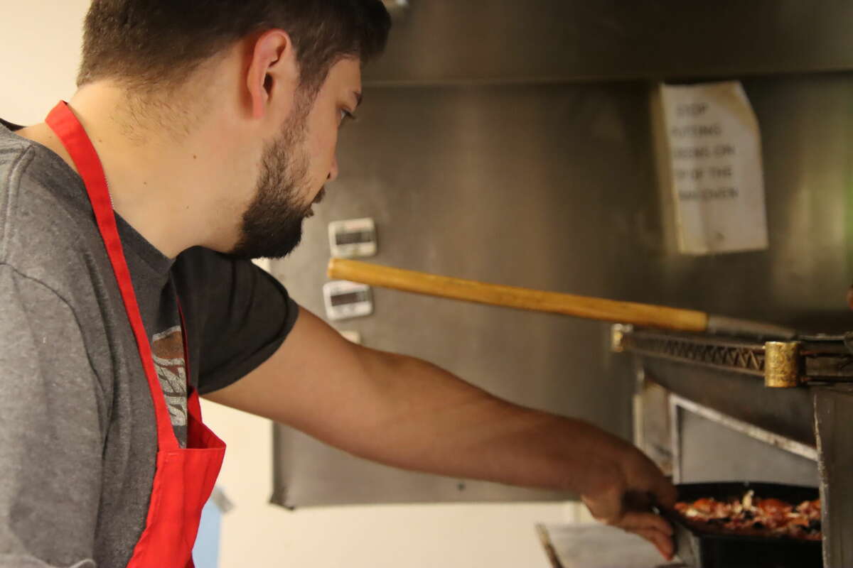 On the job: Max Milne puts together his first pizza with Pizza Dude
