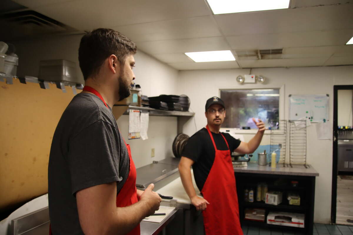 On the job: Max Milne puts together his first pizza with Pizza Dude