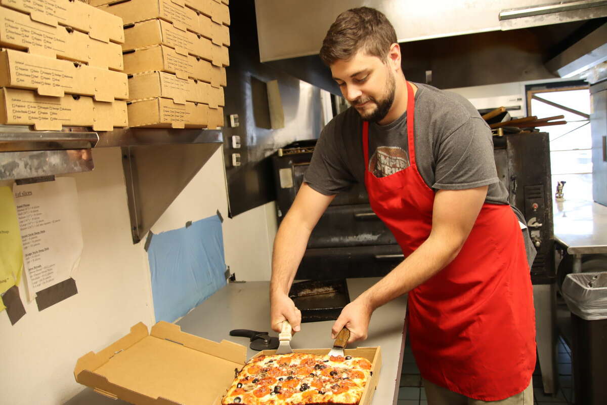 On the job: Max Milne puts together his first pizza with Pizza Dude