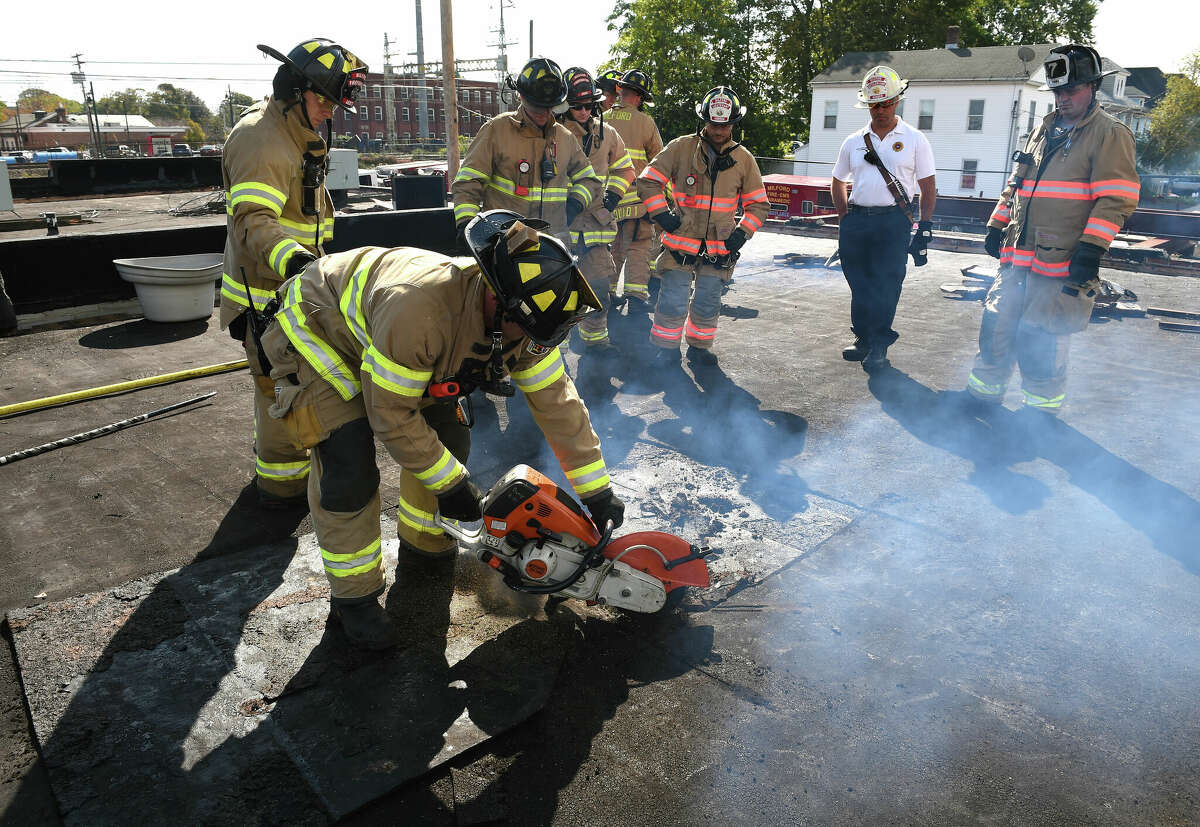 Milford firefighters practice cutting into roof of River Street site
