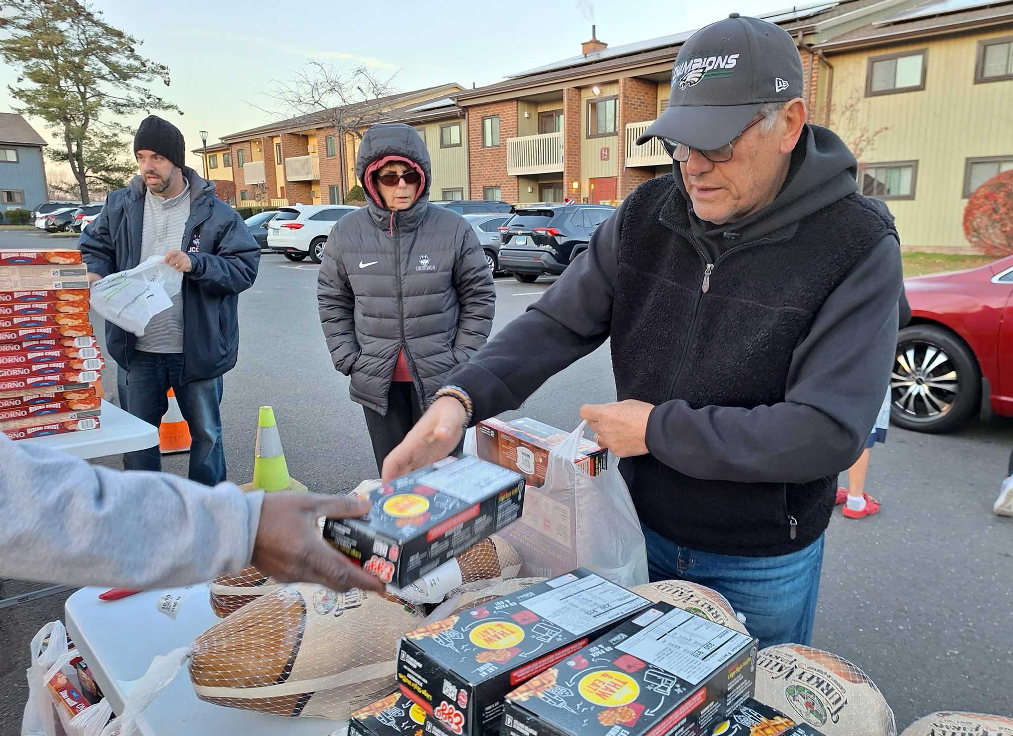 PHOTOS: UConn's Auriemma hands out Thanksgiving meals in Manchester