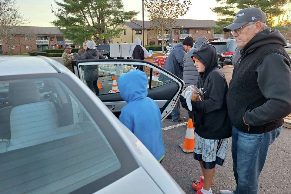 PHOTOS: UConn's Auriemma hands out Thanksgiving meals in Manchester