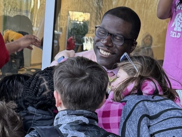 Norwalk Principal Thomas swarmed with hugs as he returns from leave