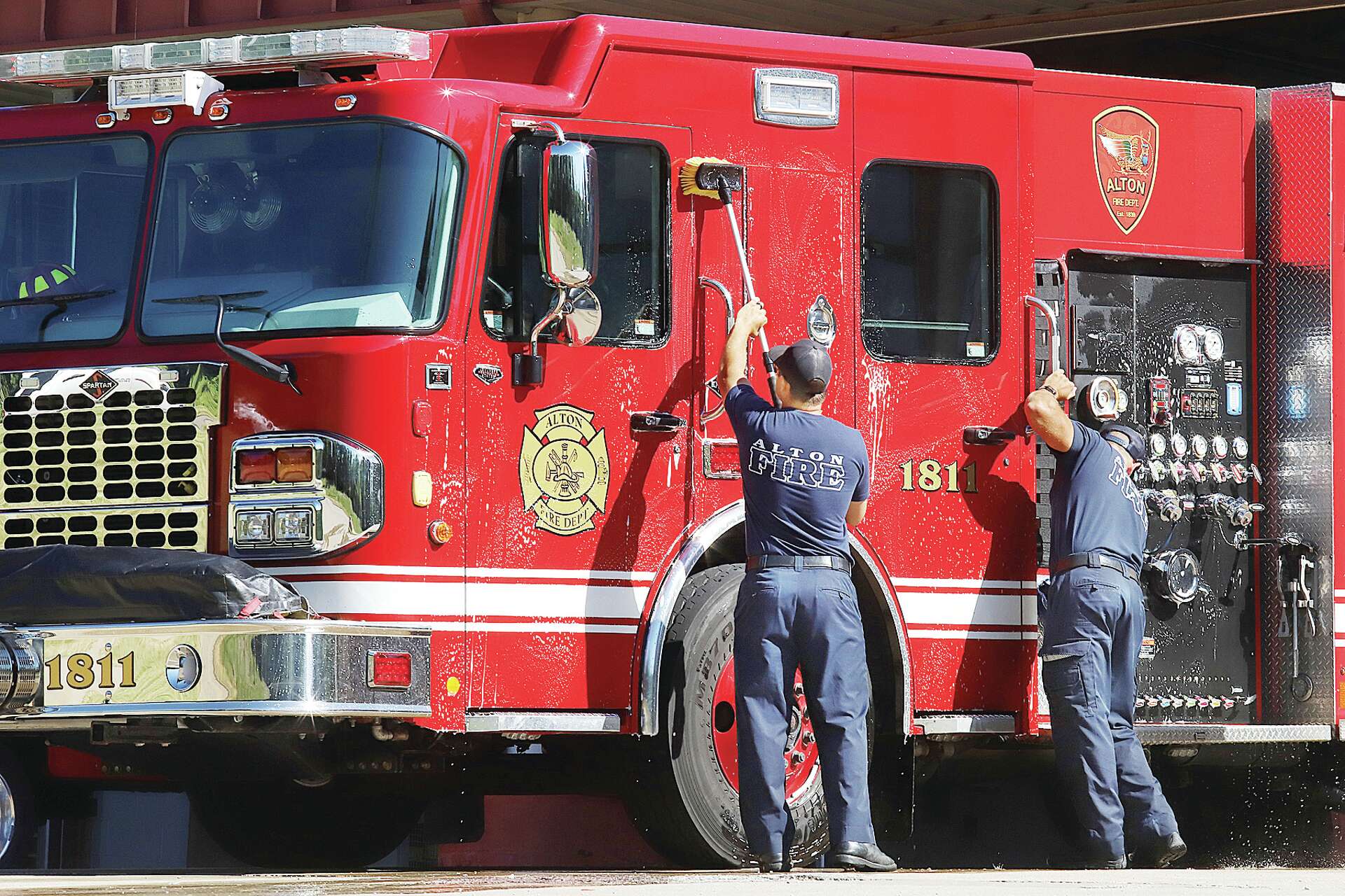 Alton firefighters wash new pumper truck at station