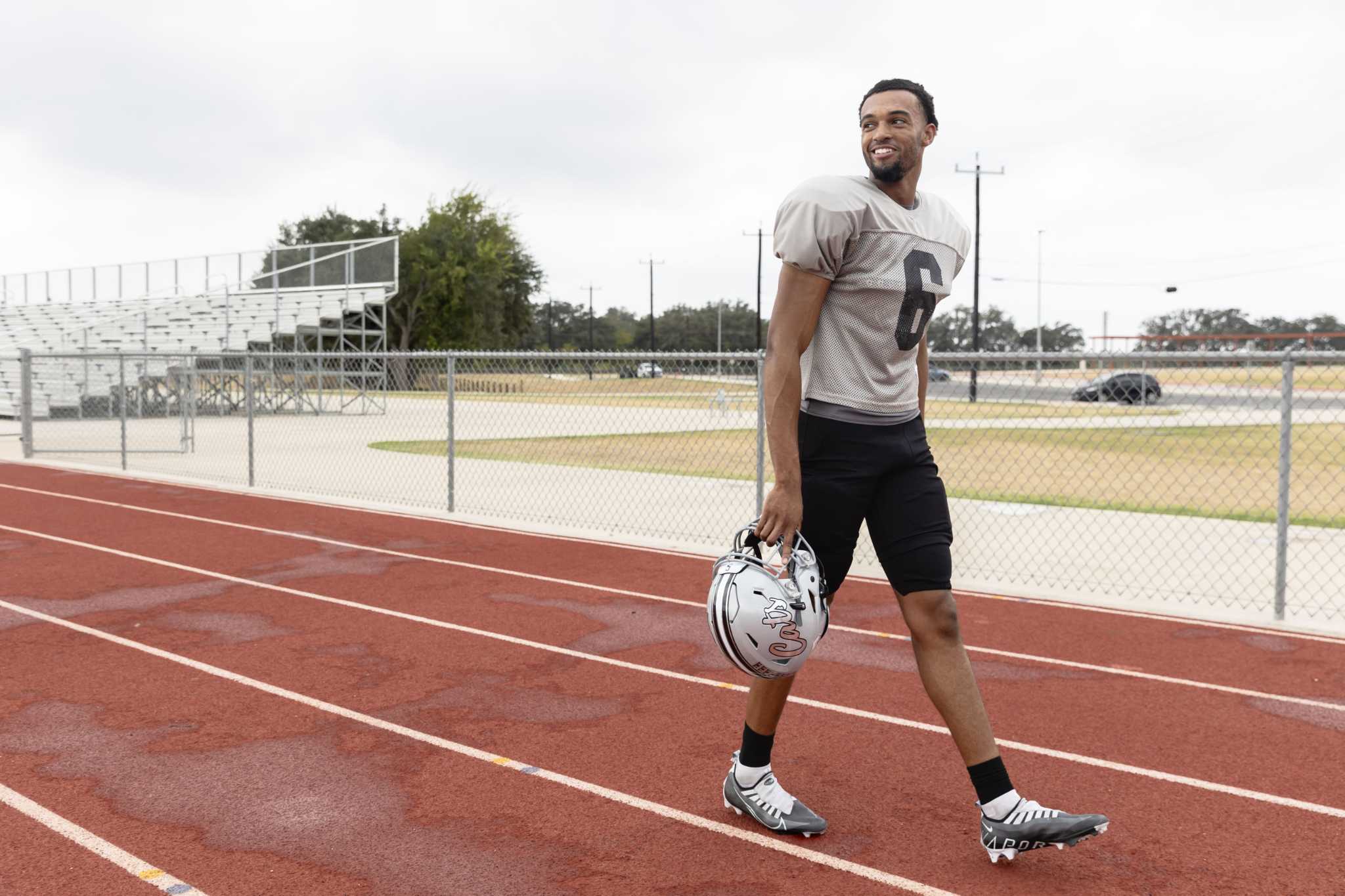 Sotomayor football player Darrell Bacon balances football with band