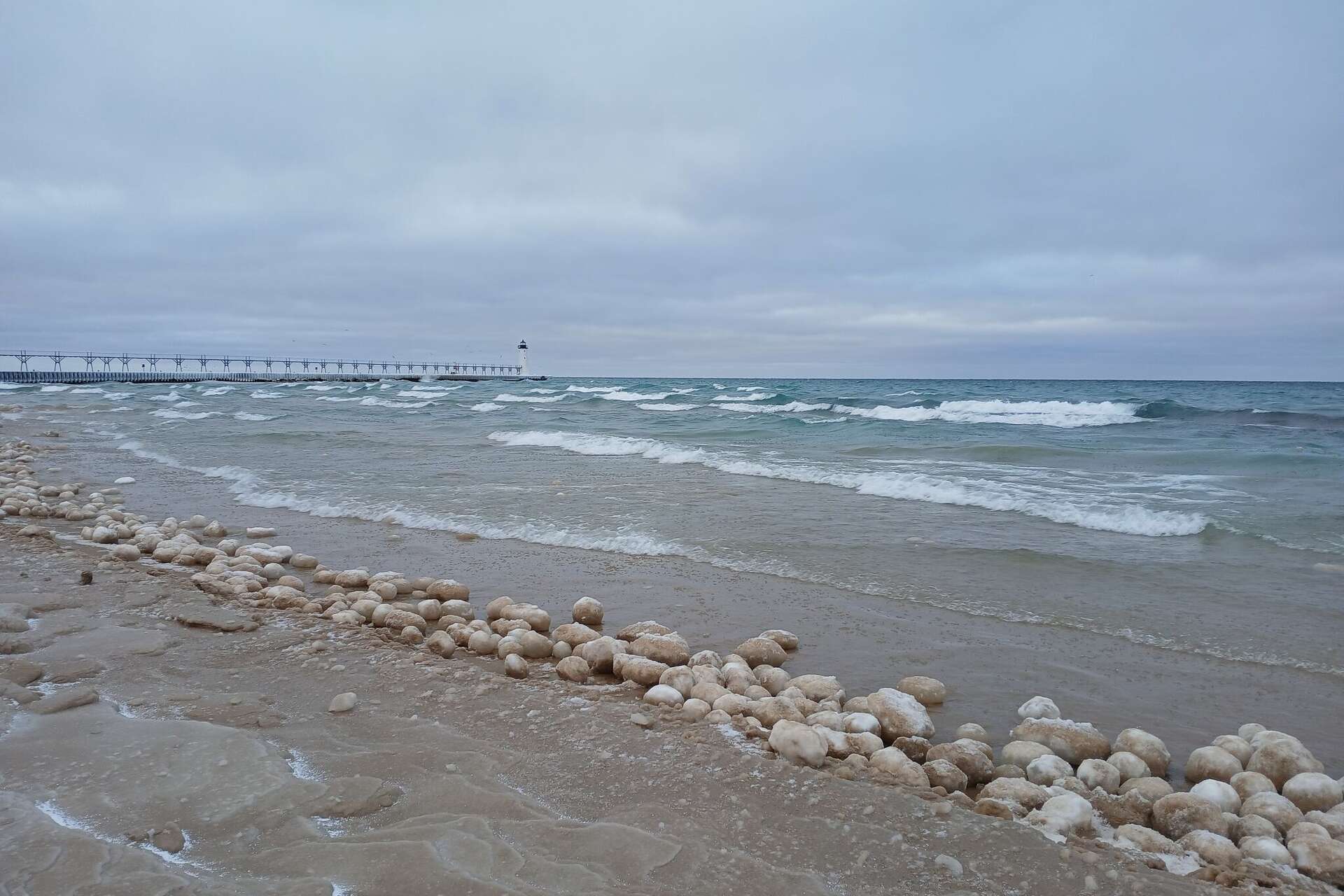 Lake Michigan ice balls roll into Manistee's lakeshore after high wind