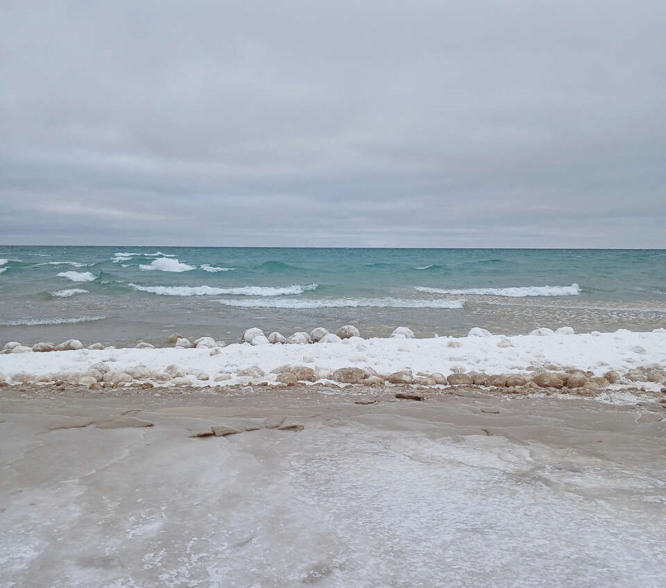 Lake Michigan ice balls roll into Manistee's lakeshore after high wind