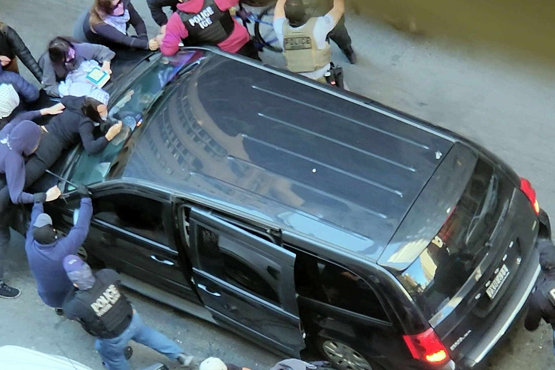 Protesters cling to departing ICE van as chaotic scene erupts