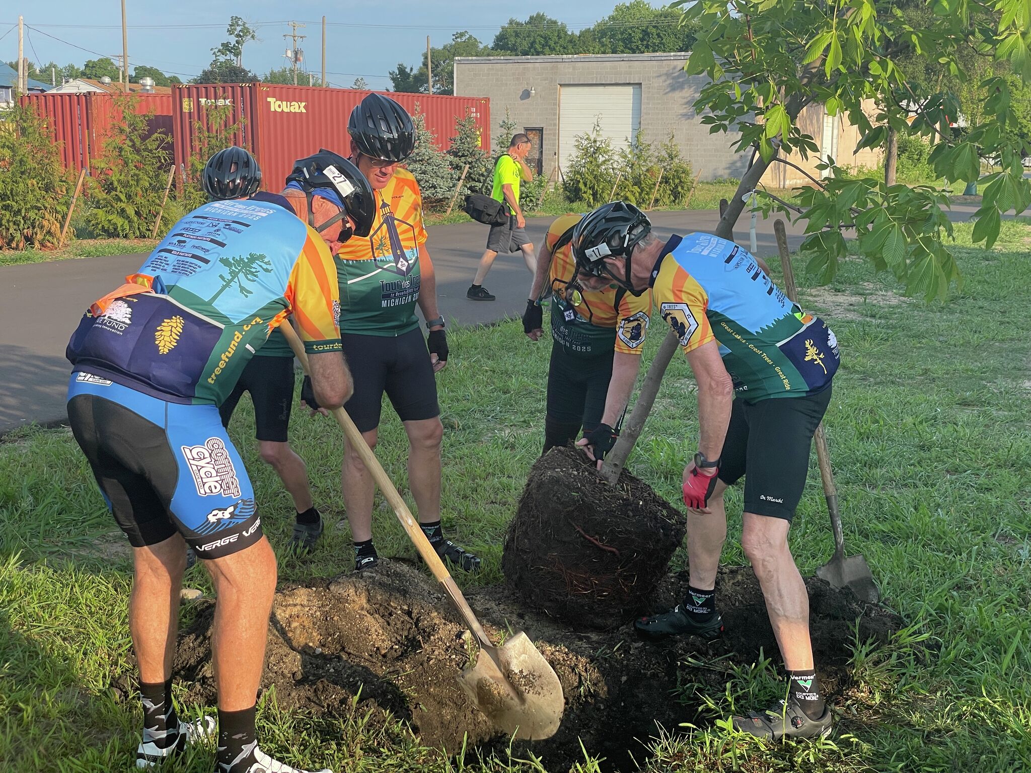 Cyclists from the Tour des Trees plant a tree in Big Rapids Michigan