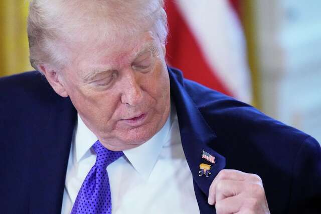 Trump wears a new 'Happy Trump' lapel pin, but insists he's never happy