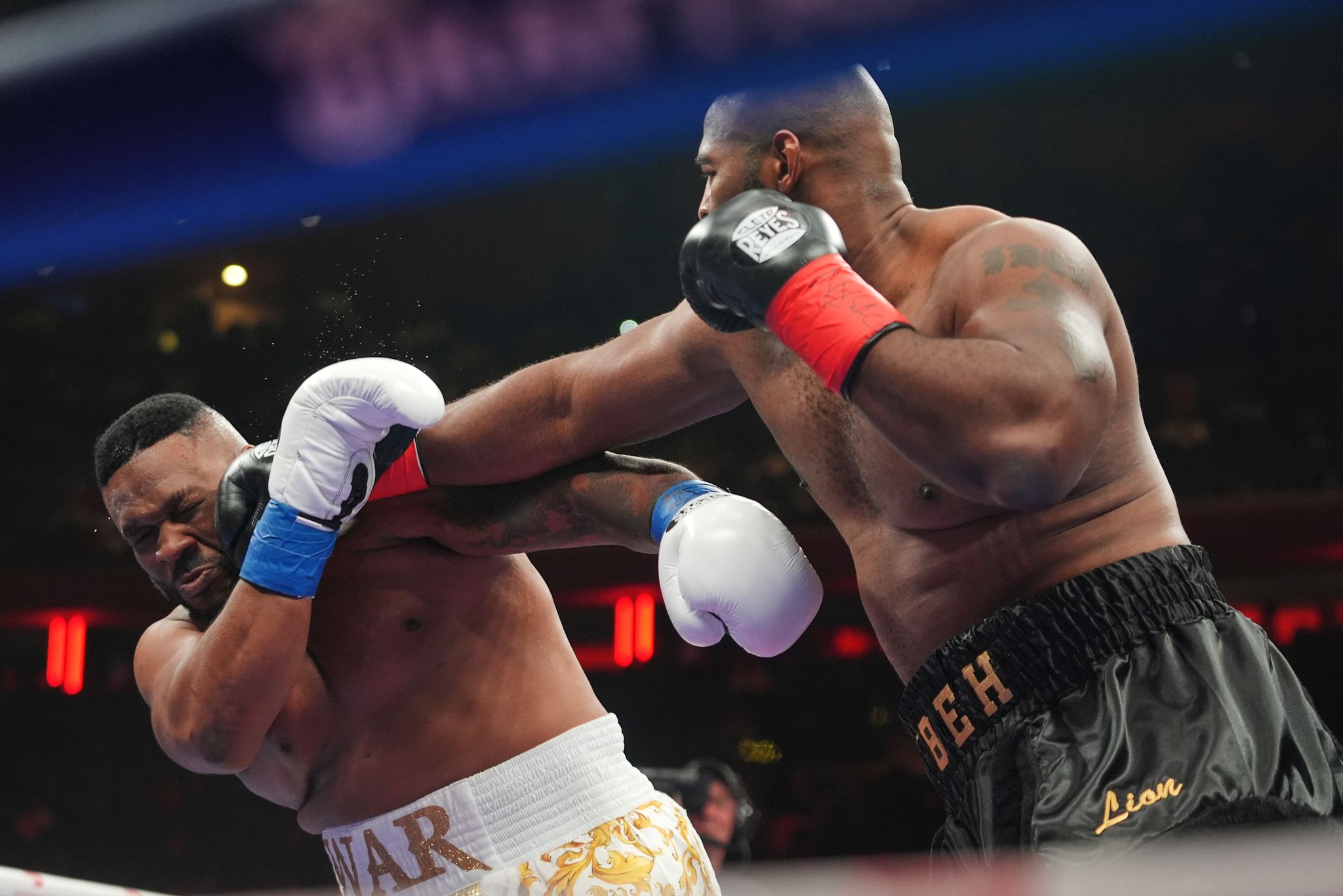 Boxer Jarrell Miller has his hairpiece knocked upward by a punch, then ...