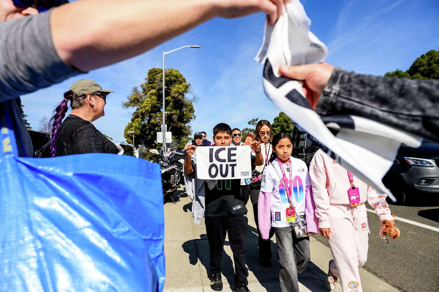 Activists hand out ‘ICE OUT’ towels to fans for Super Bowl protest
