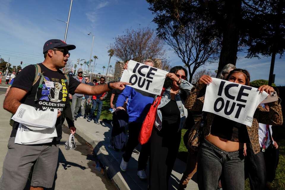 Activists hand out ‘ICE OUT’ towels to fans for Super Bowl protest