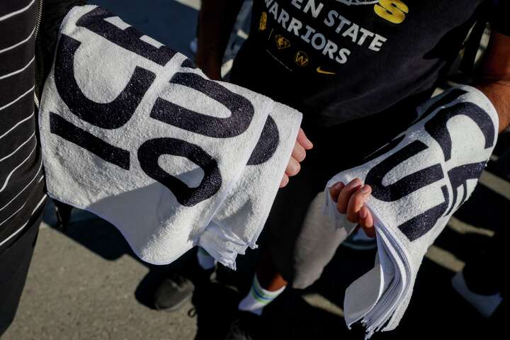 Activists hand out ‘ICE OUT’ towels to fans for Super Bowl protest