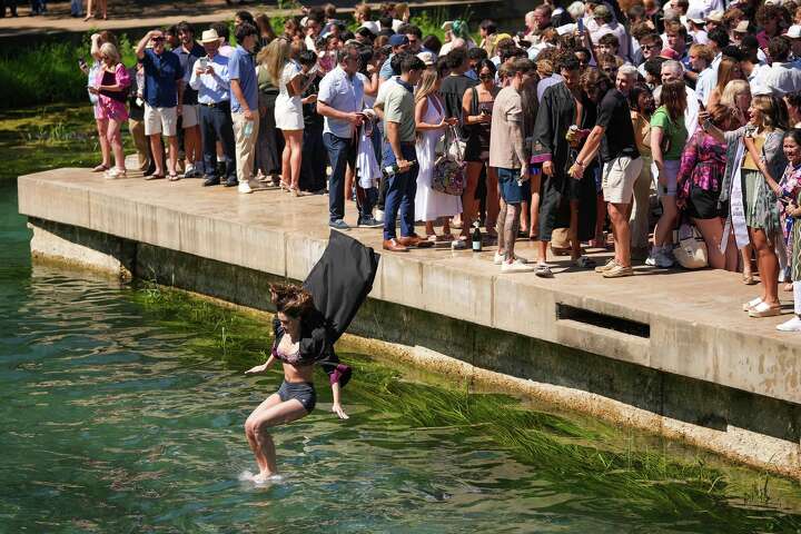 Texas State graduates jump into San Marcos River after commencement