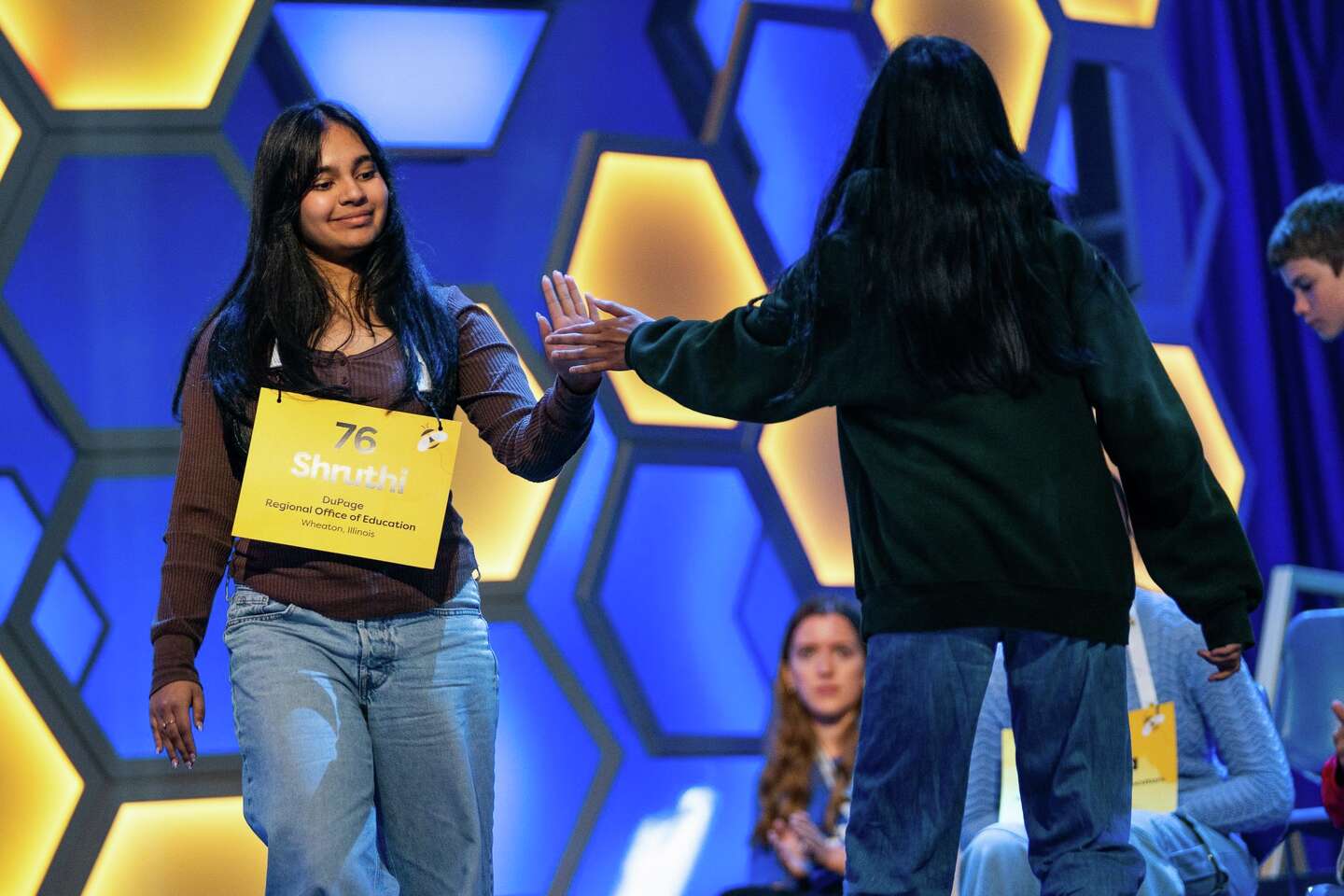 Photos of students competing for the Scripps National Spelling Bee trophy