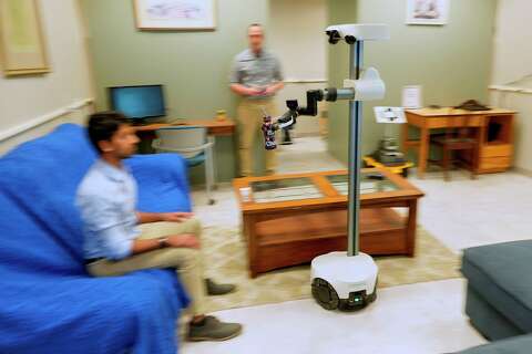 A robot is helping an ailing couple stay in their home. Are more to ...