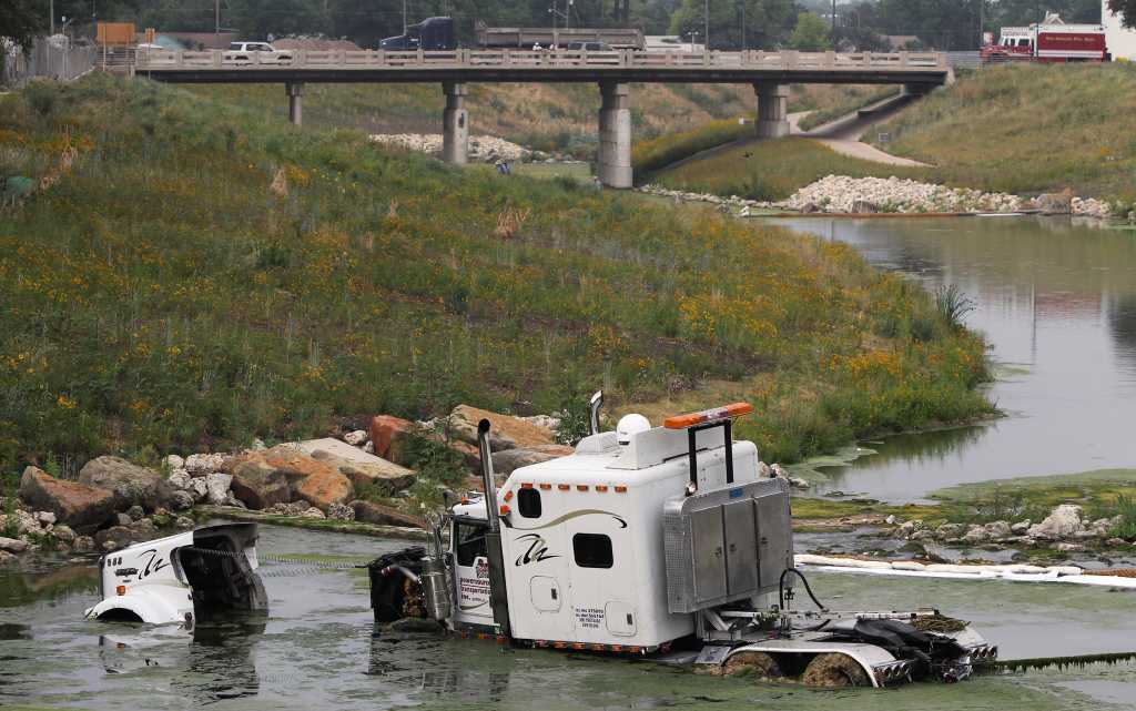 Big rig lands in river, leaks diesel fuel