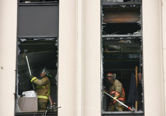 Fire crews work to brace burned office building