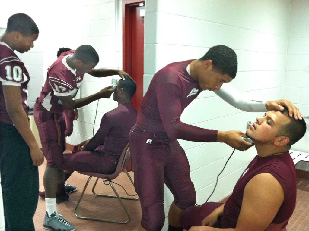 Central football players turn field house into barbershop before games