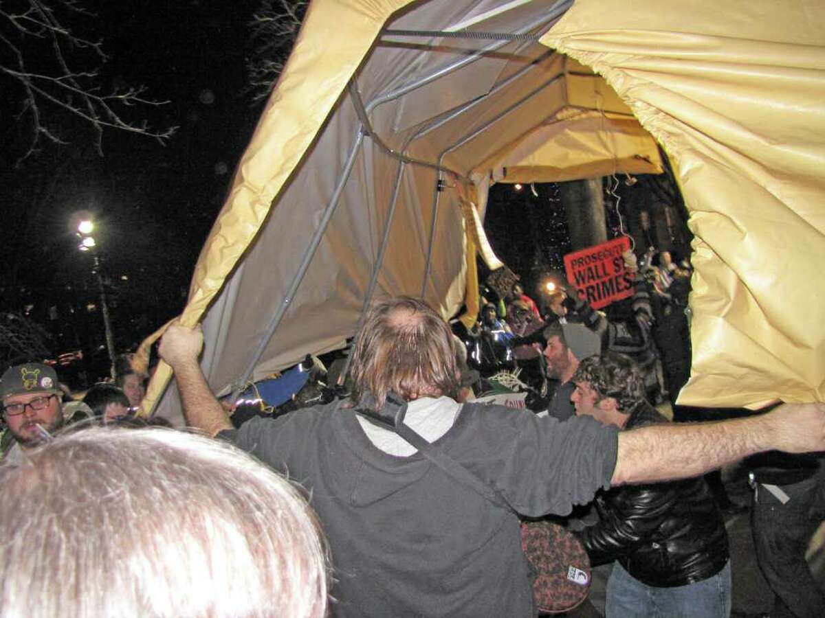 Protesters, police tussle as tents fall
