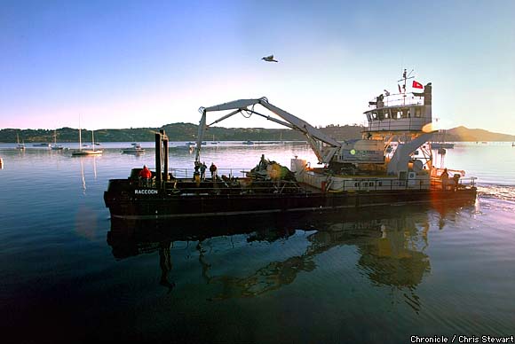Fishing for flotsam / A dedicated crew pulls out everything from cups ...