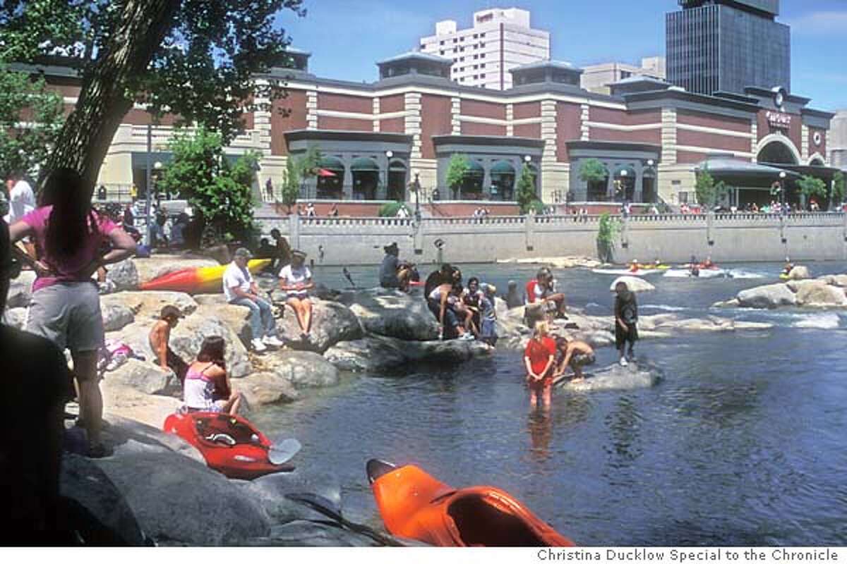 A whitewater river park runs through it / Kayaks, tubes shoot rapids in ...