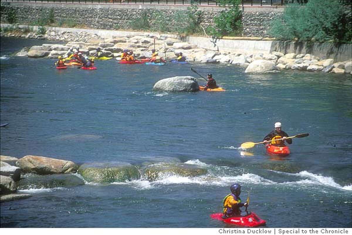 A whitewater river park runs through it / Kayaks, tubes shoot rapids in ...