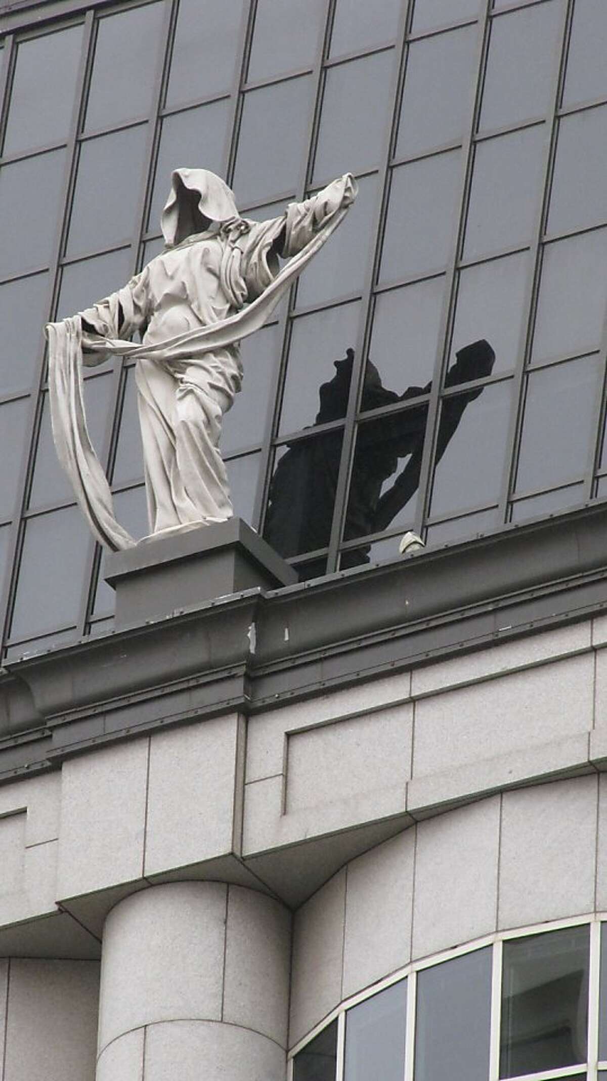 12 faceless figures crown a 23-story tower