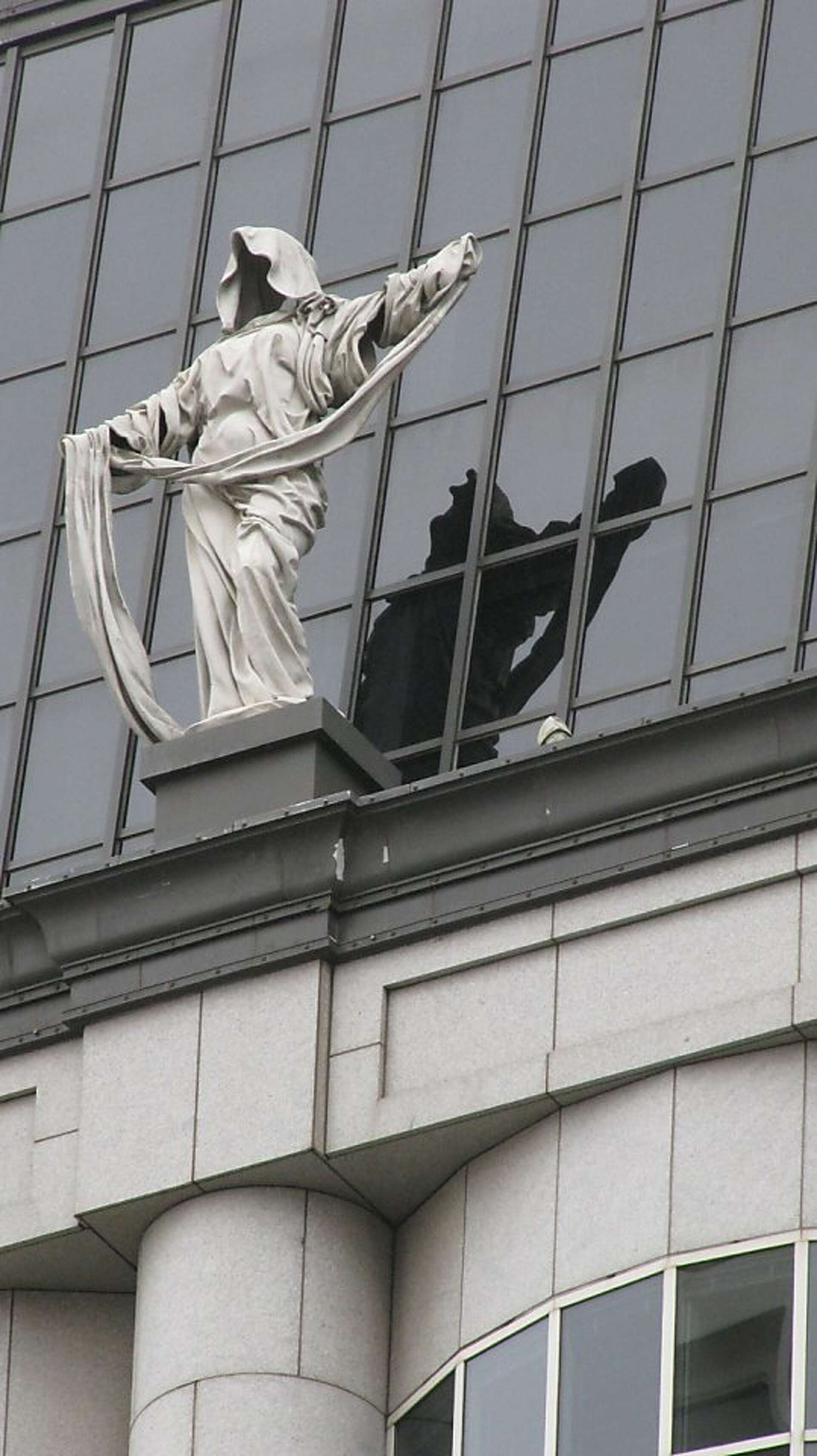 12 faceless figures crown a 23-story tower