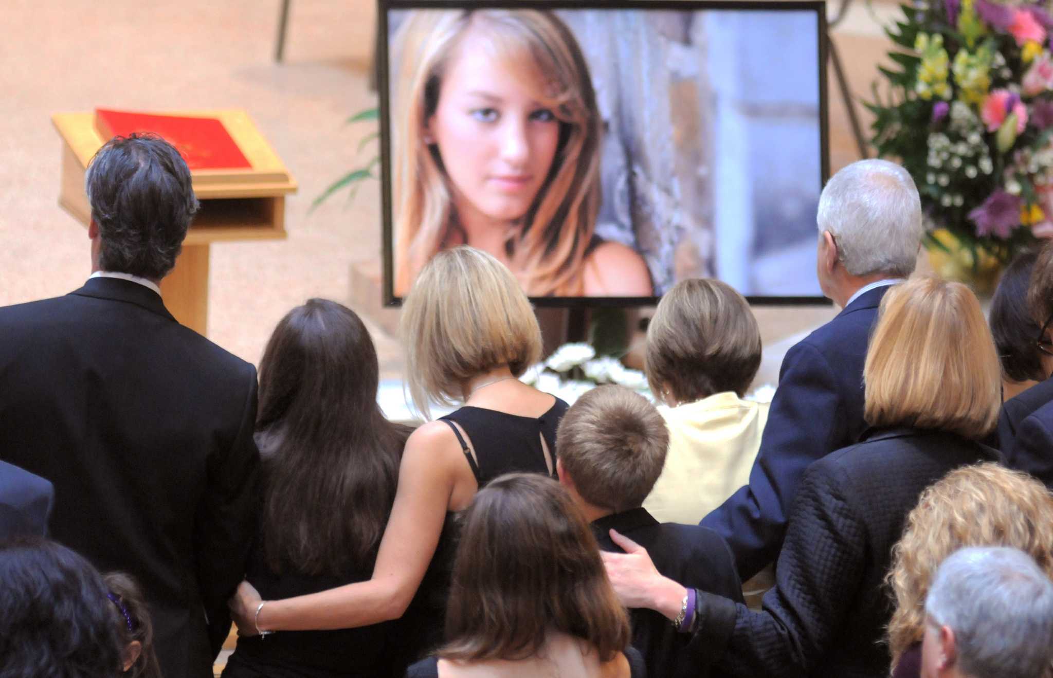 Mourners don purple at beaten student's funeral
