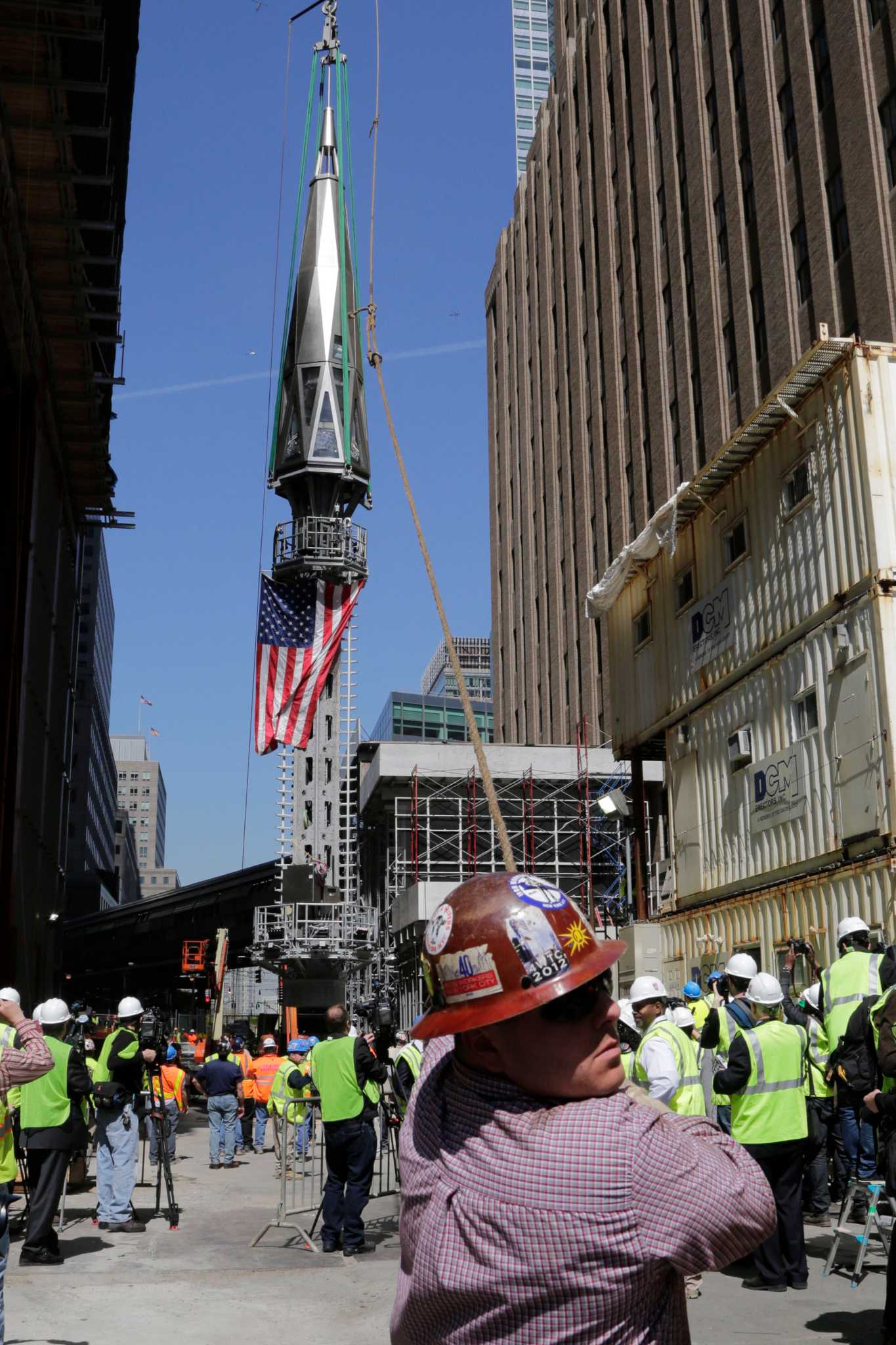 Flag-covered spire hoisted to WTC roof