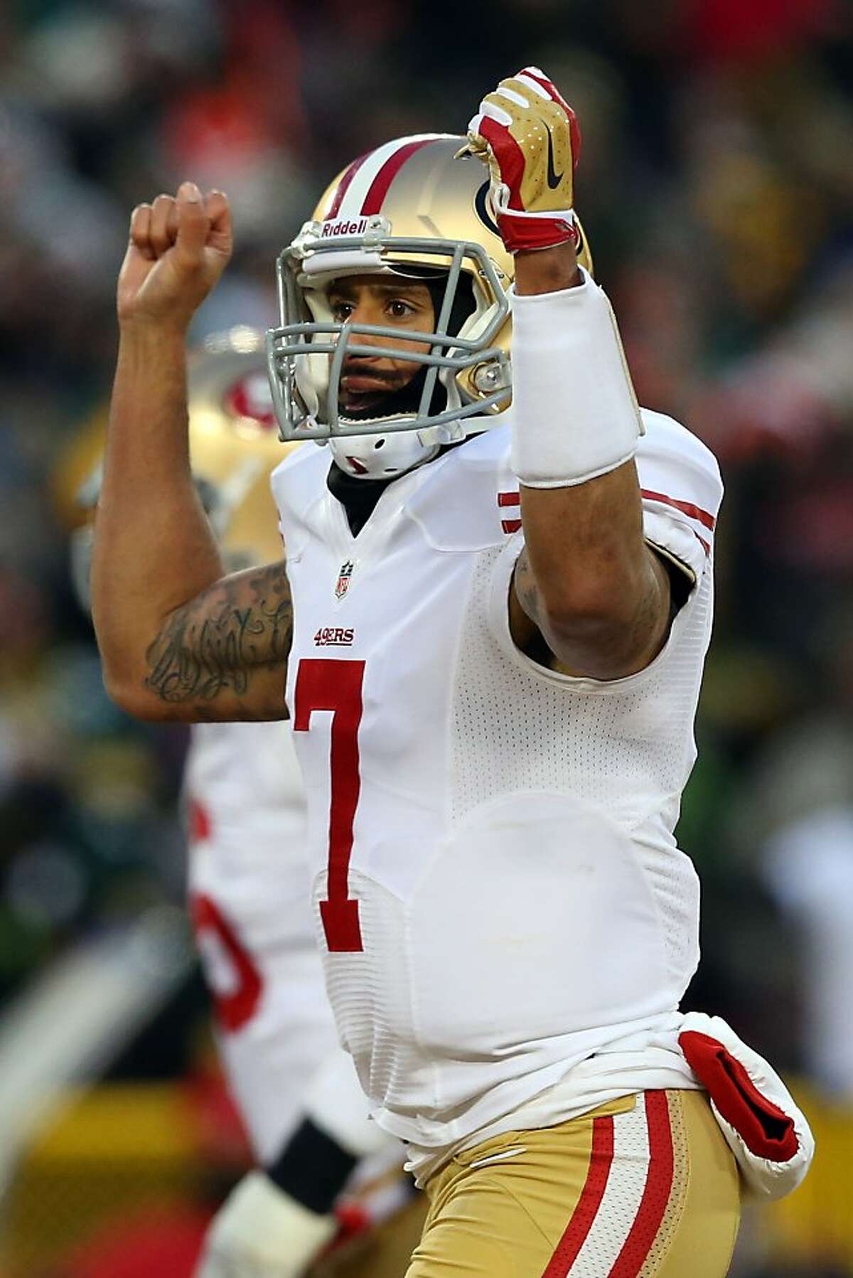 Kaepernick bares arms, tats, toughness for victory