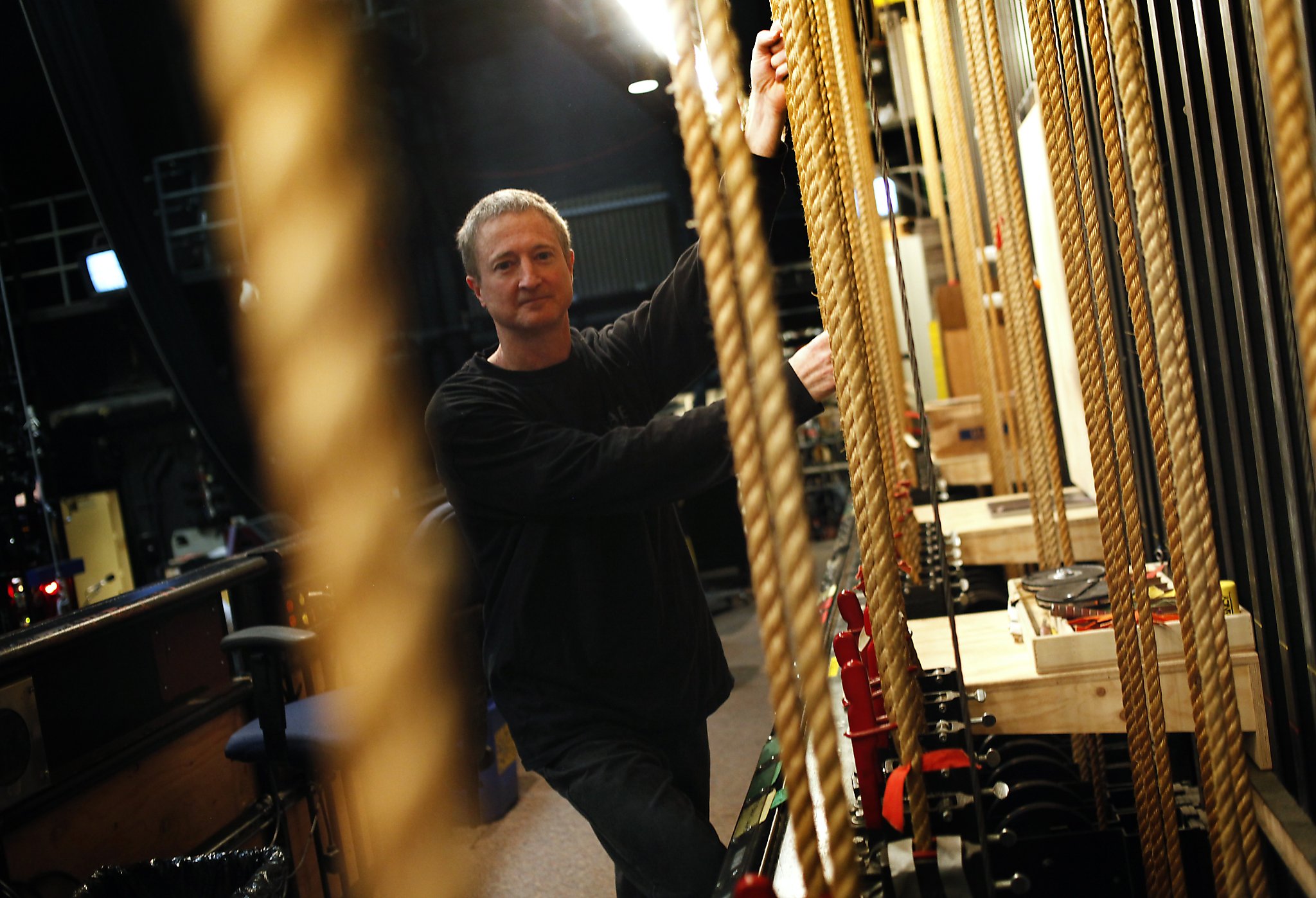 Flyman at reins of the ballet behind the scenes