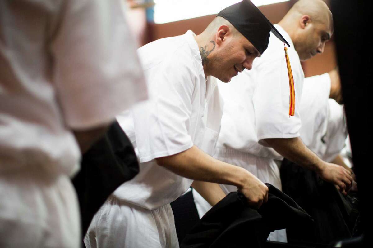 Gowns cover prison whites as first class of Darrington seminarians graduate