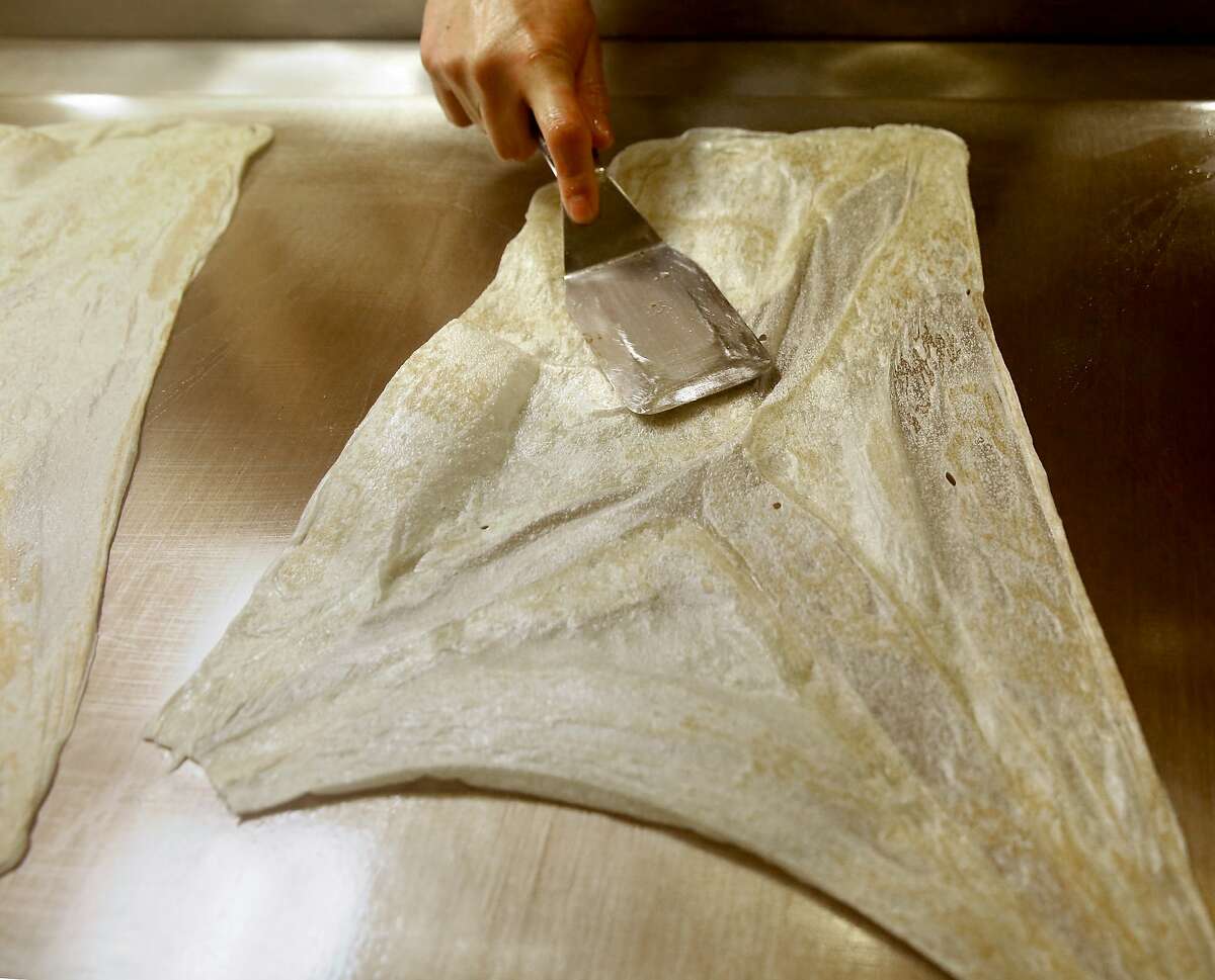 Making roti canai, a flaky Malaysian flatbread, is a spectacle