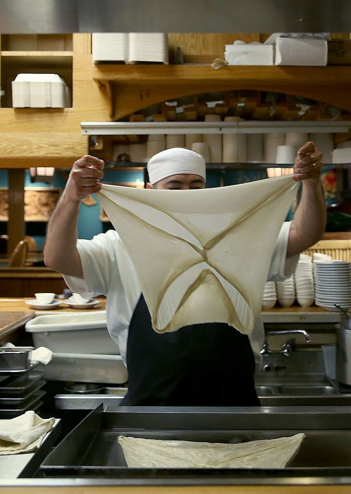 Making roti canai, a flaky Malaysian flatbread, is a spectacle