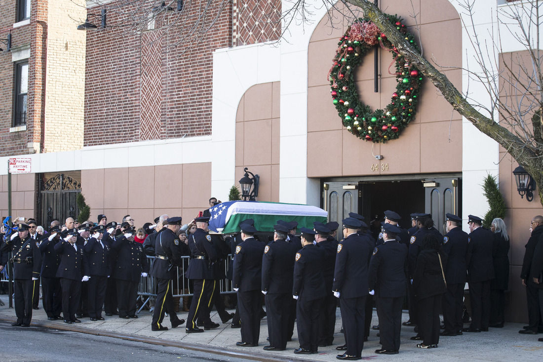 Fellow officers salute NY cop's flag-draped casket