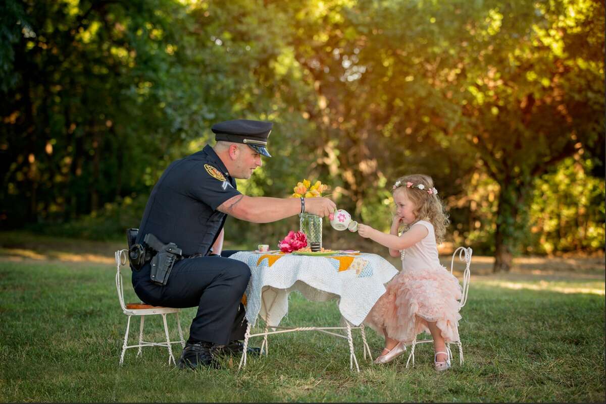 Police officer has tea time with little girl whose life he saved