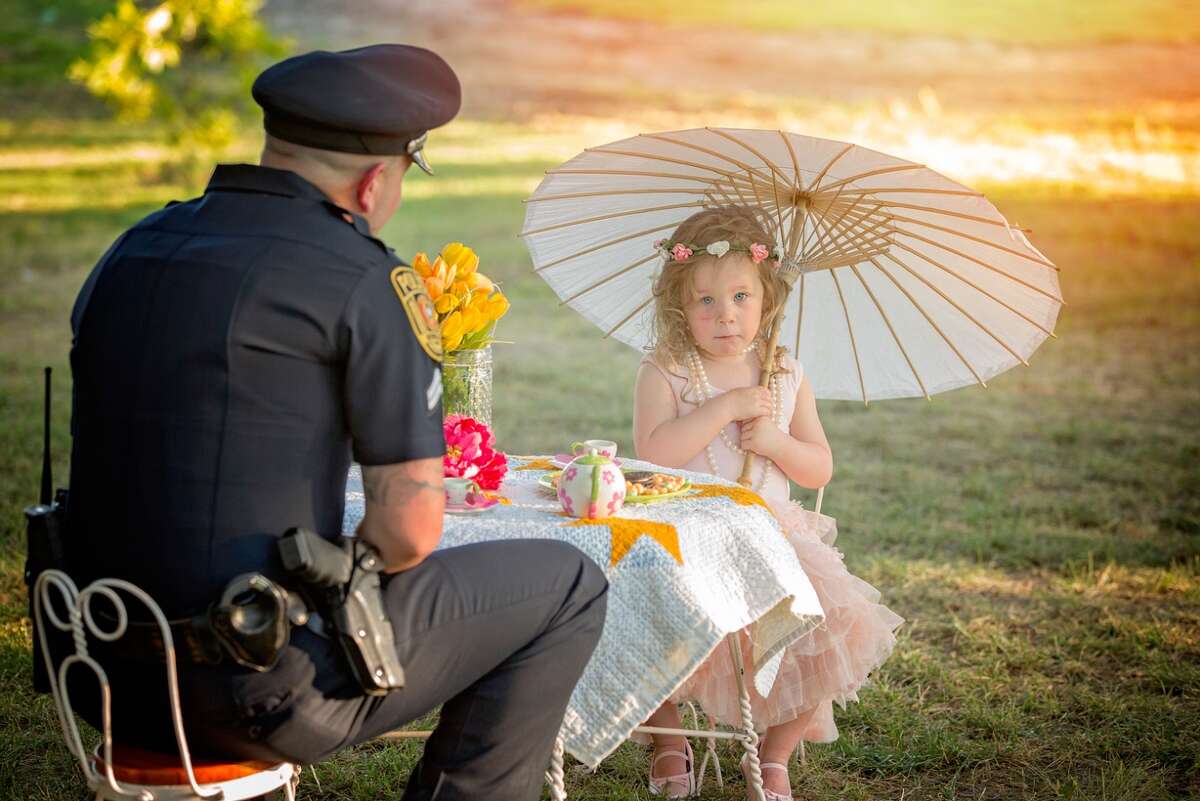 Police officer has tea time with little girl whose life he saved