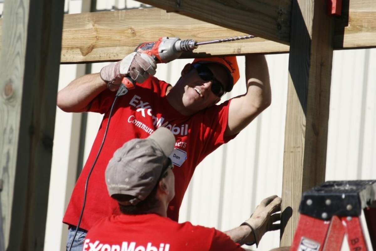 ExxonMobil volunteers work with New Horizons patrons to complete ...